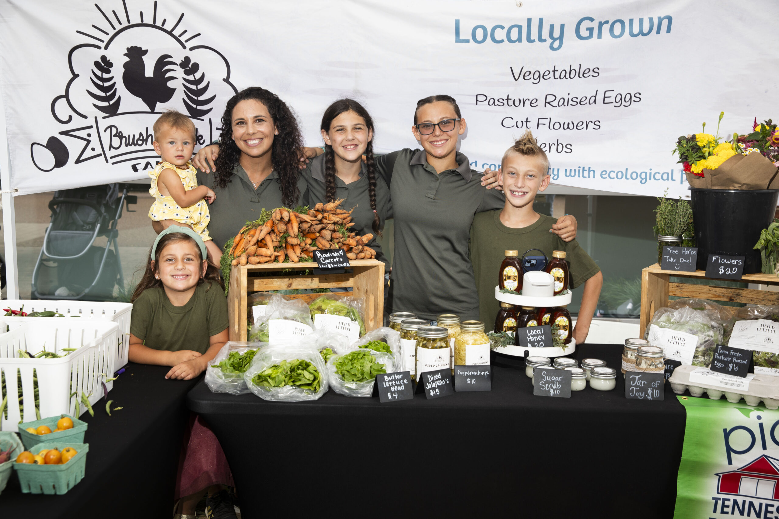 Why is there a 1-year-old staffing a booth at the Farmers' Market? Her ...